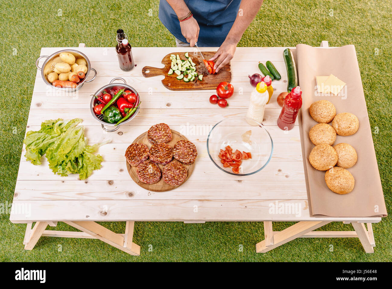 man making burgers and cutting red tomatoes outdoors Stock Photo - Alamy