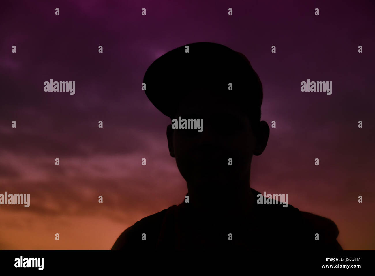 silhouette of boy with cap in front of wonderful sunset Stock Photo - Alamy