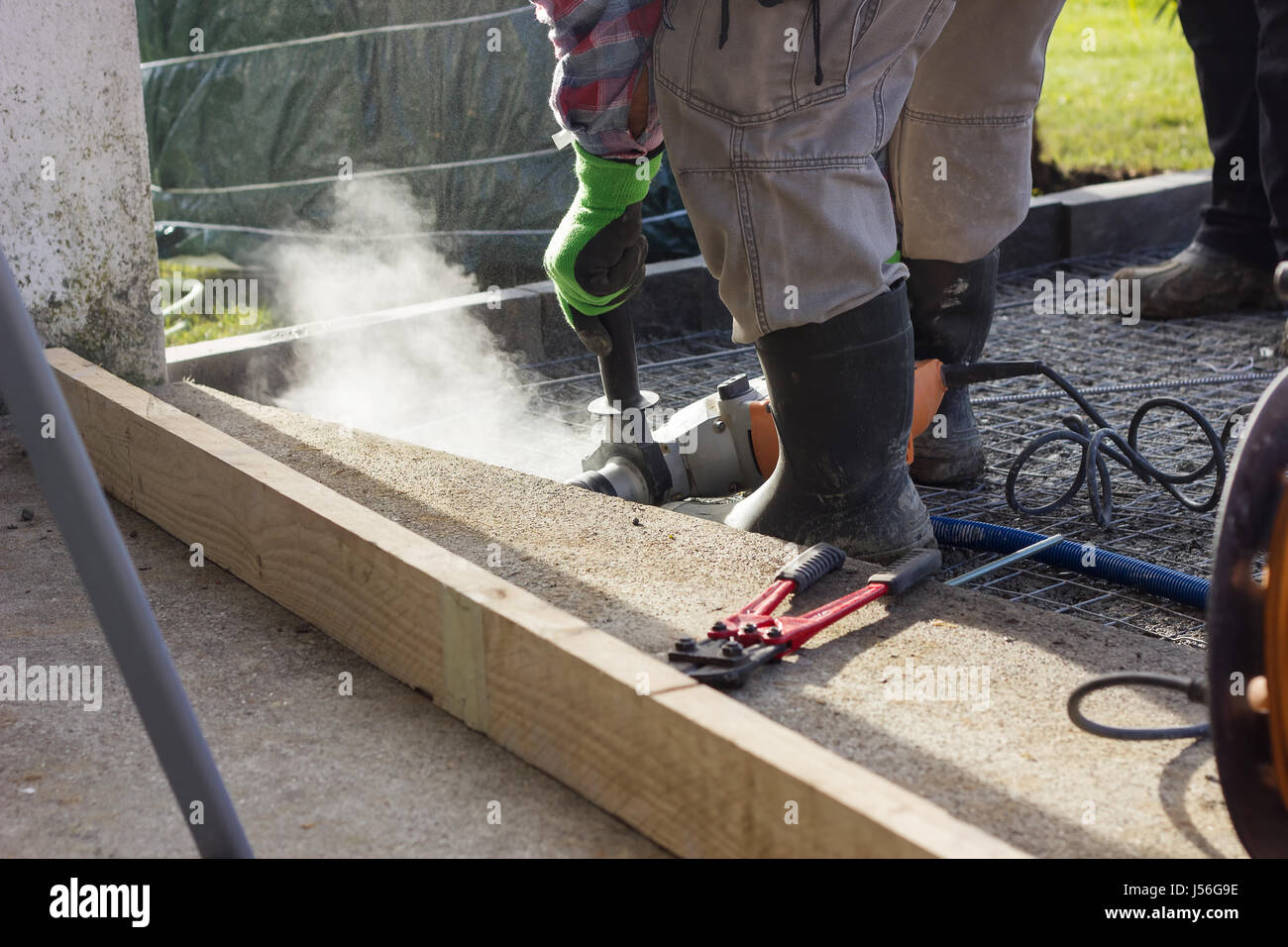 handyman using hammer drill outside at the garden to drilling hole ...