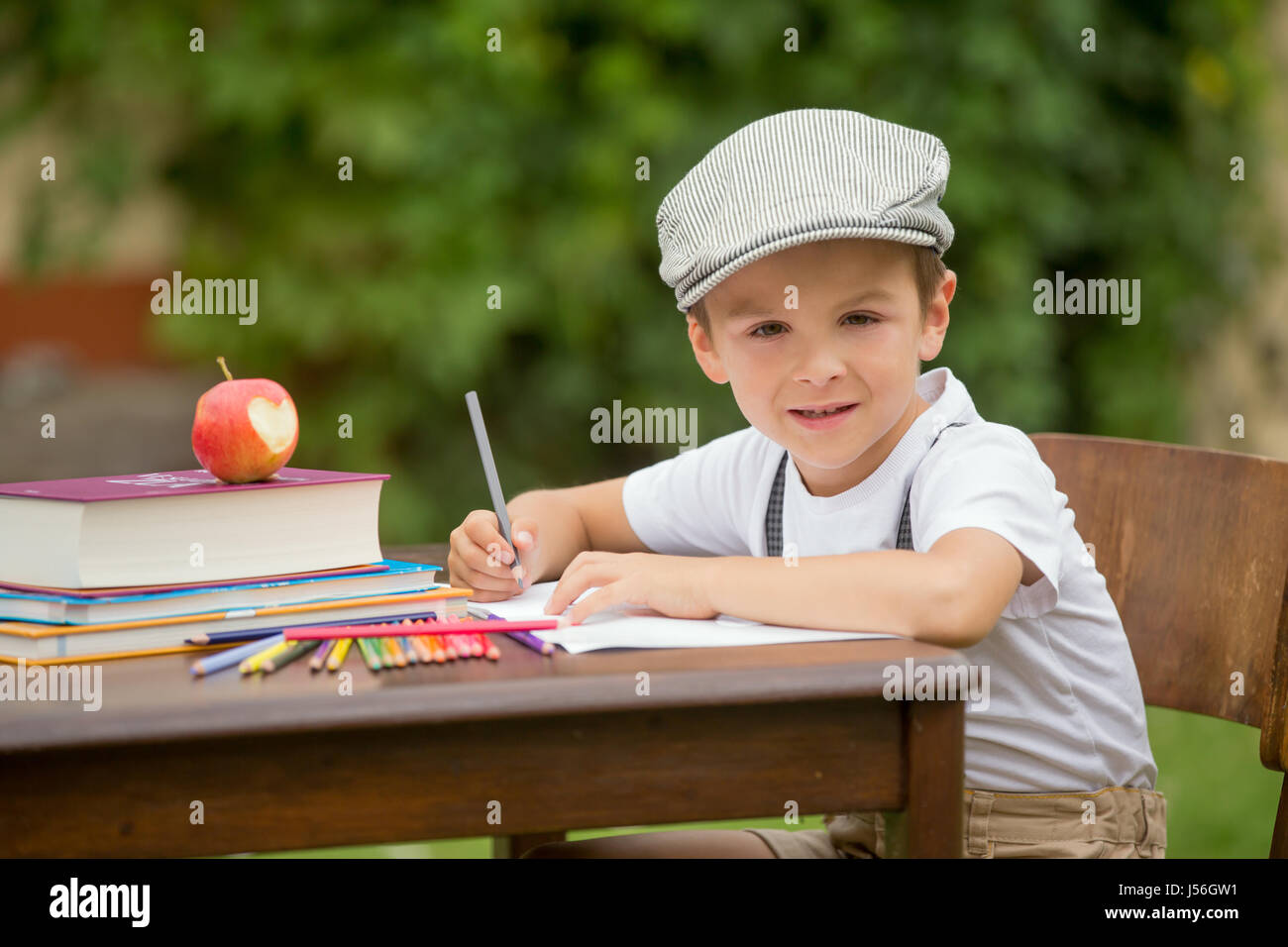 Boy, writing his homework from school, drawing and writing in his ...