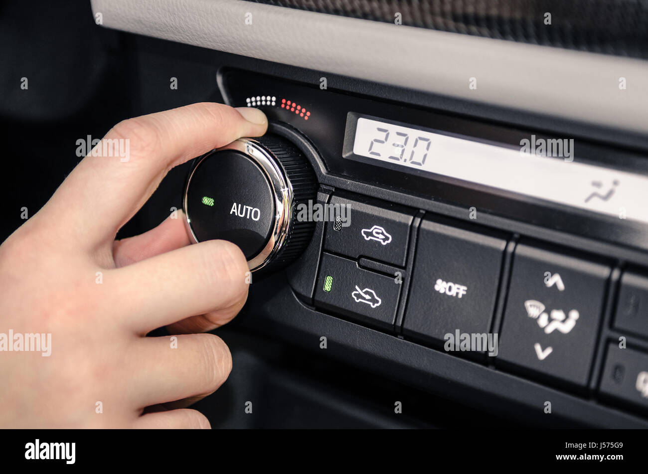 Hand adjusting the internal temperature of the car by turning the ...