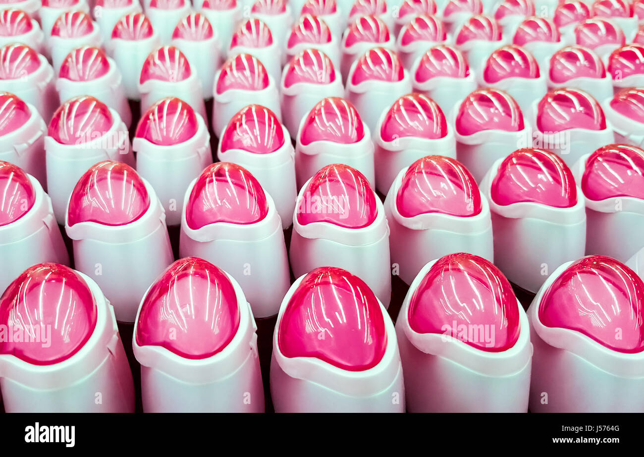 Deodorant, bottles with pink lids in a row. Background Stock Photo - Alamy