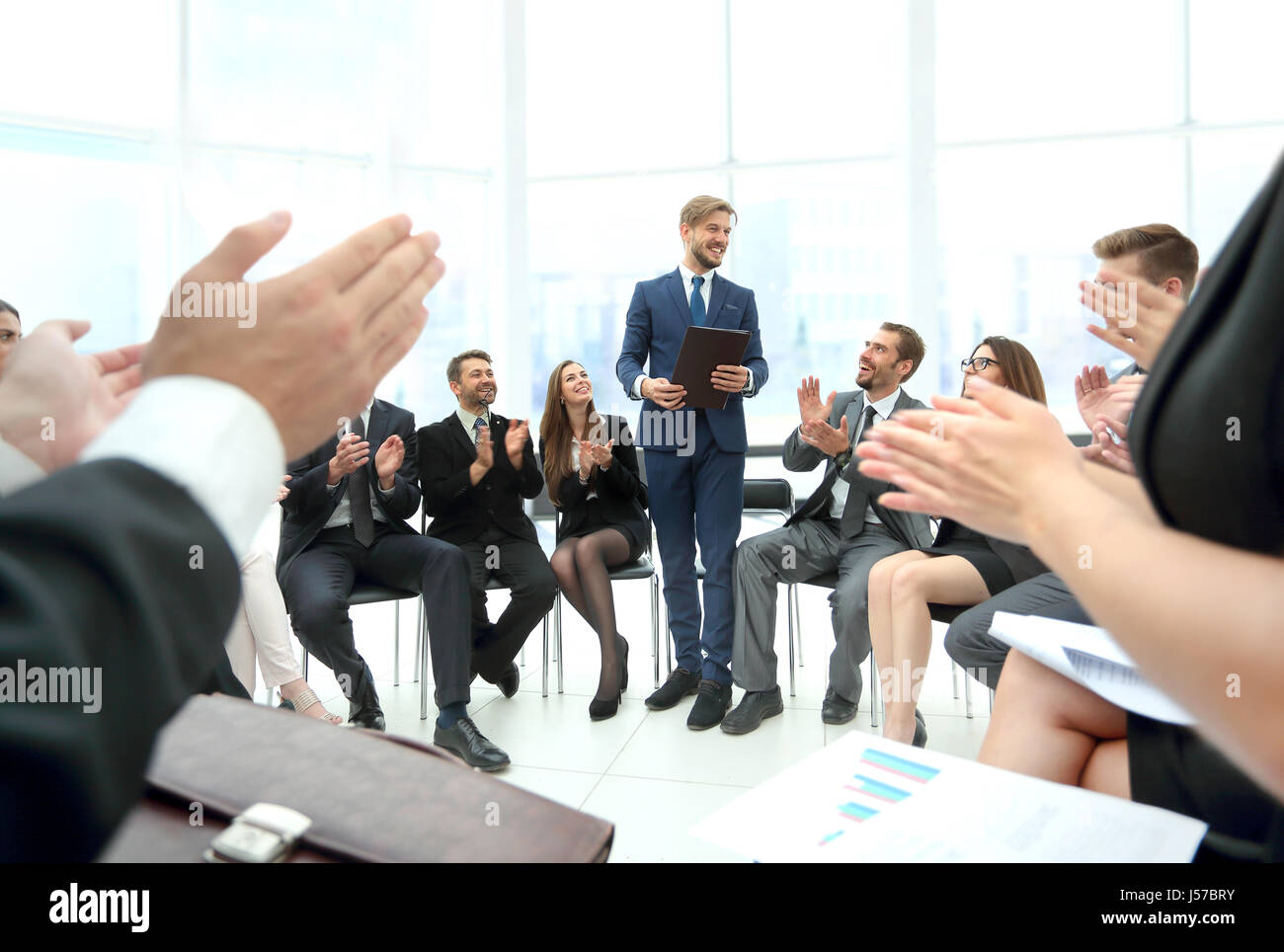 Business group greets leader with clapping and smiling Stock Photo - Alamy