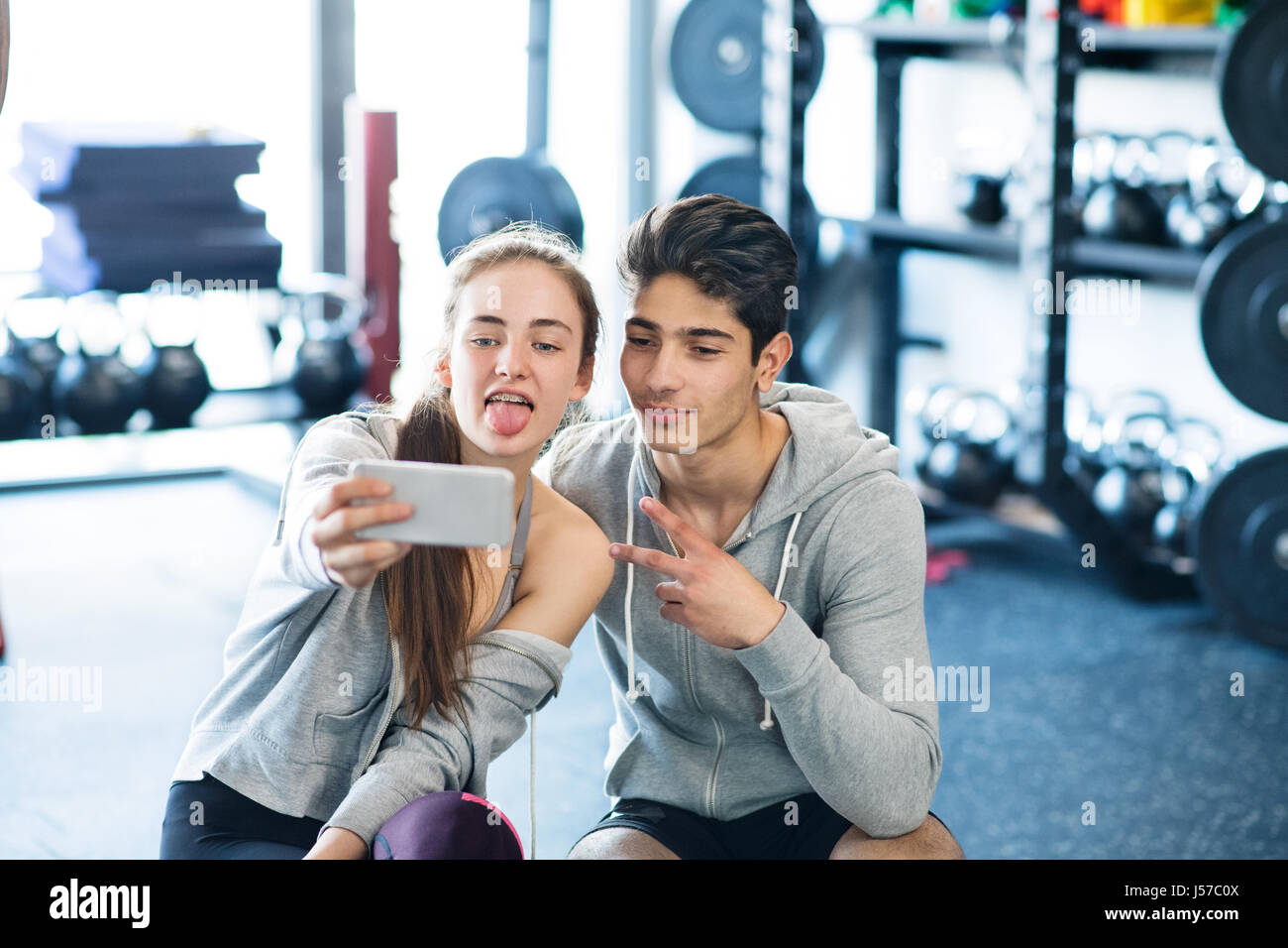Fit couple in modern crossfit gym with smartphone Stock Photo - Alamy