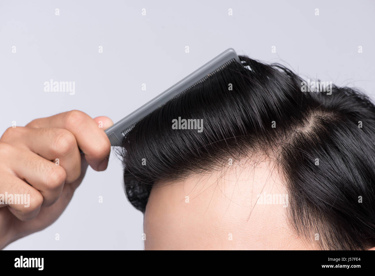 Close up photo of clean healthy man's hair. Young man comb his hair ...