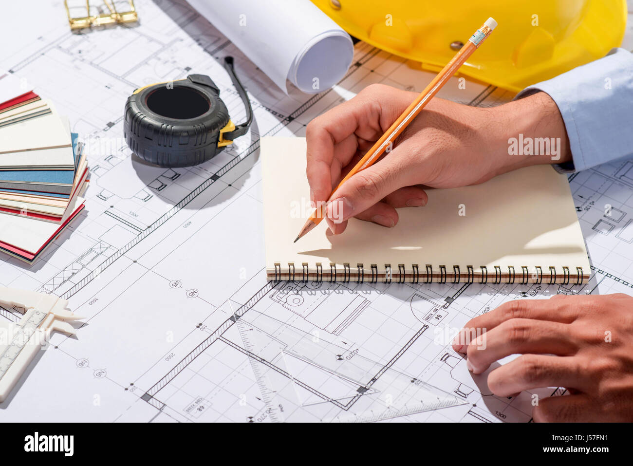 Working on blueprints. Construction project with hands writing on ...