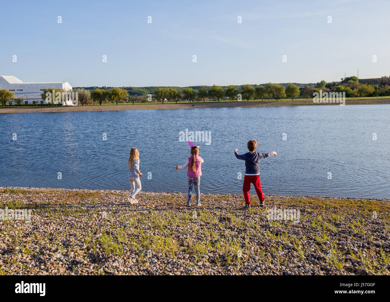 Children have fun at springtime on lakeshore Stock Photo - Alamy