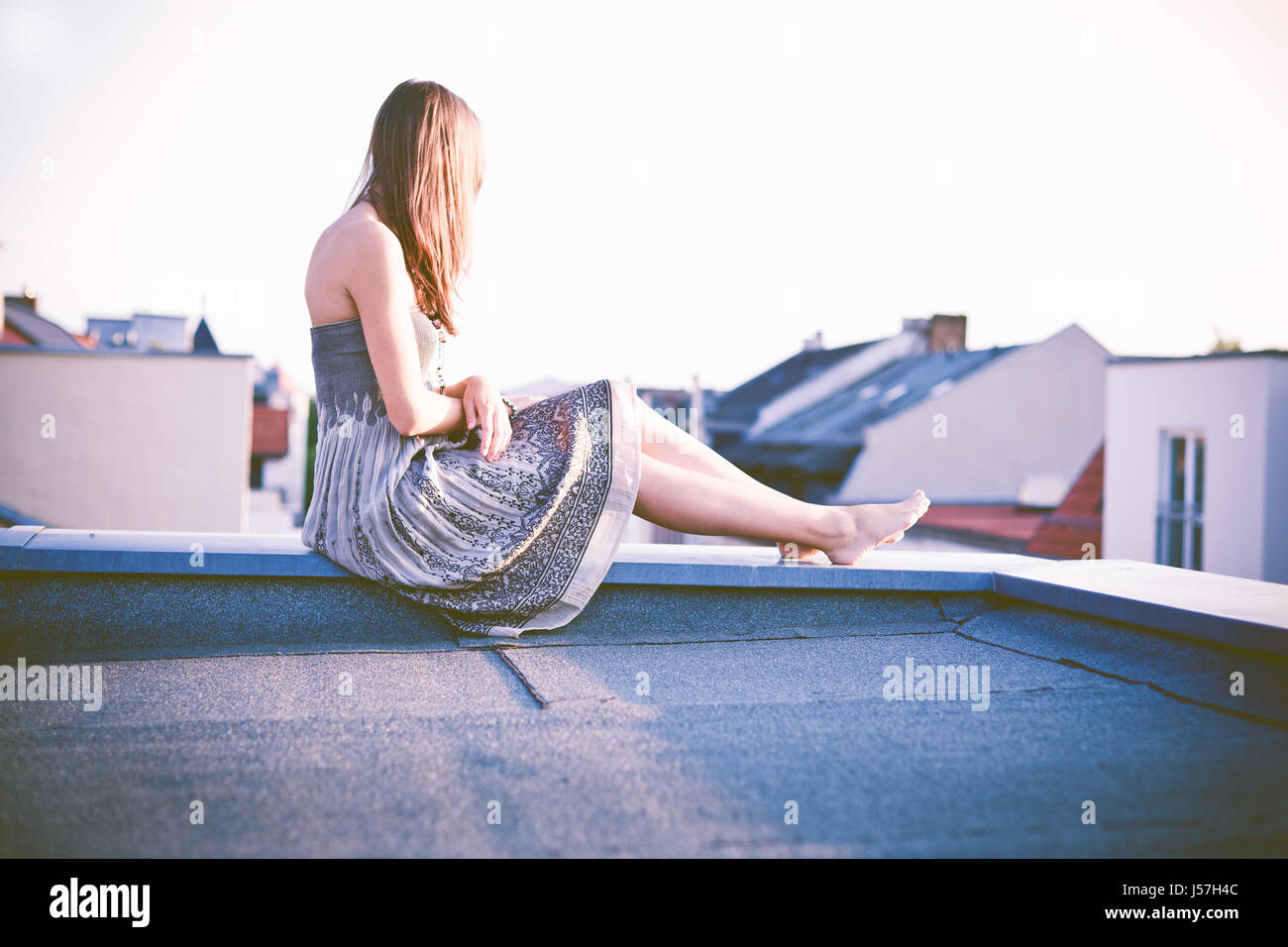 young woman sitting on rooftop Stock Photo - Alamy