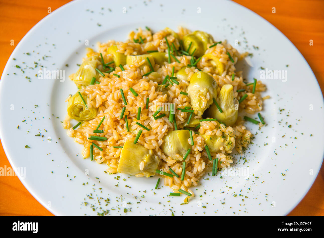 Integral rice with artichokes, chives and parsley Stock Photo - Alamy