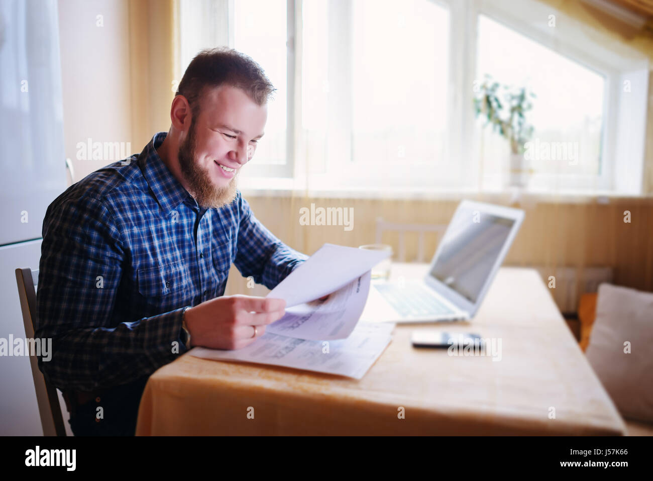 Handsome man doing some paperwork at home Stock Photo - Alamy