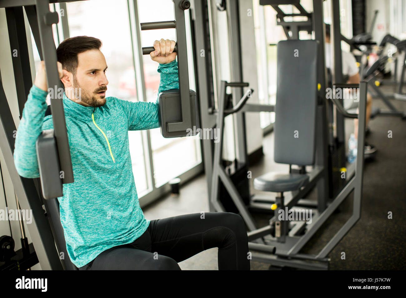 Young man exercise on an exercise machine at the gym Stock Photo - Alamy