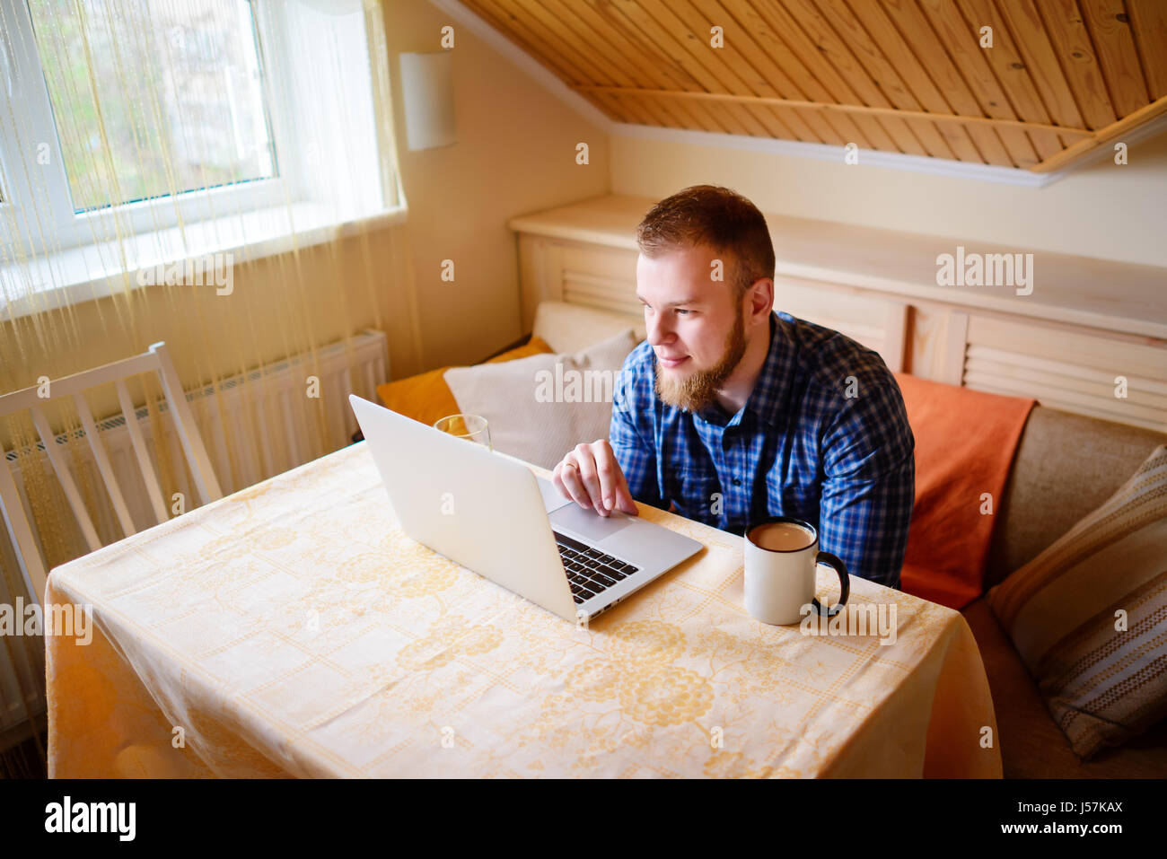 Relaxed young professional surfing the Internet on his laptop in a a ...