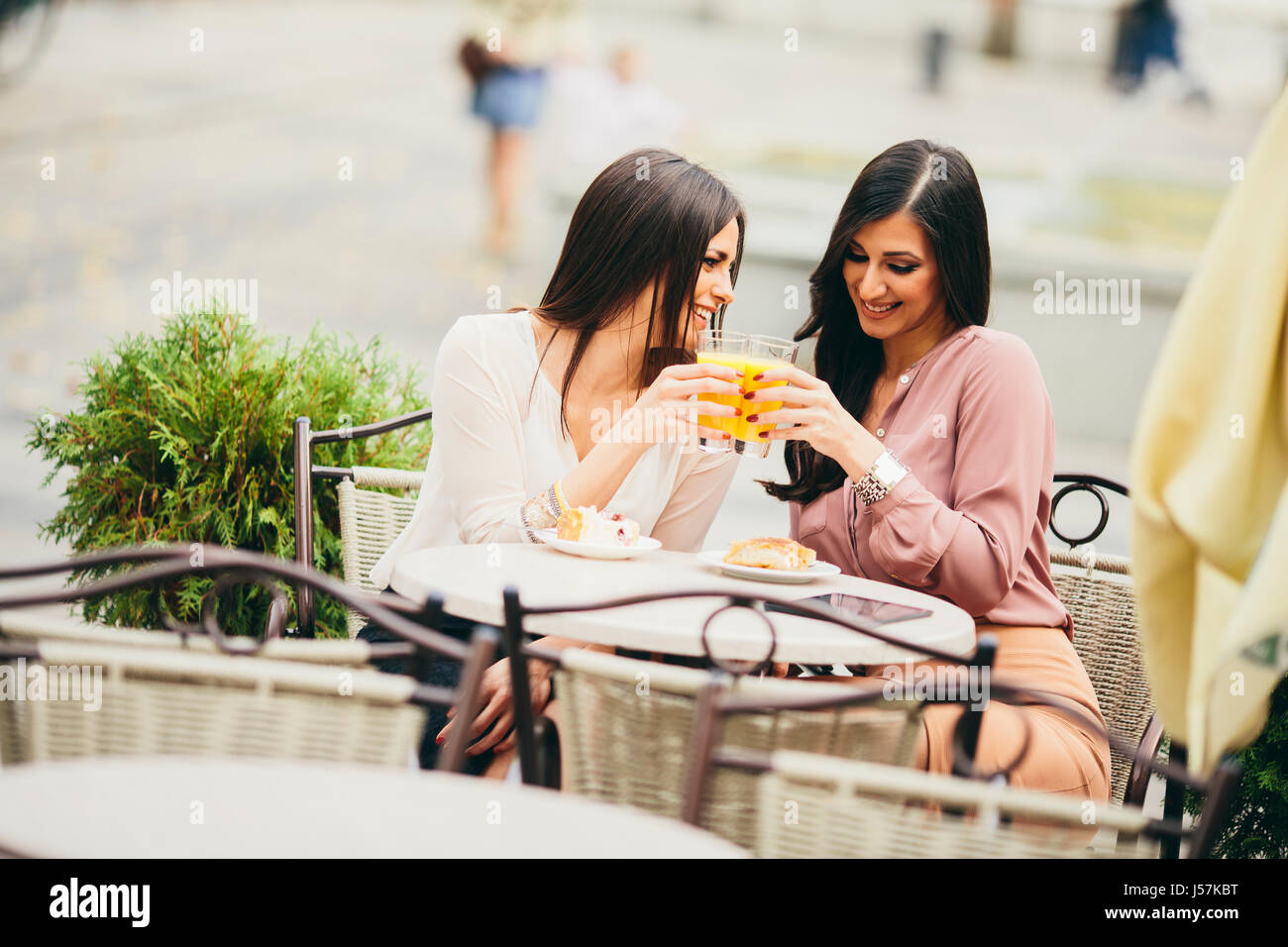 Portrait of beautiful young women eating cake at outdoors cafe Stock ...