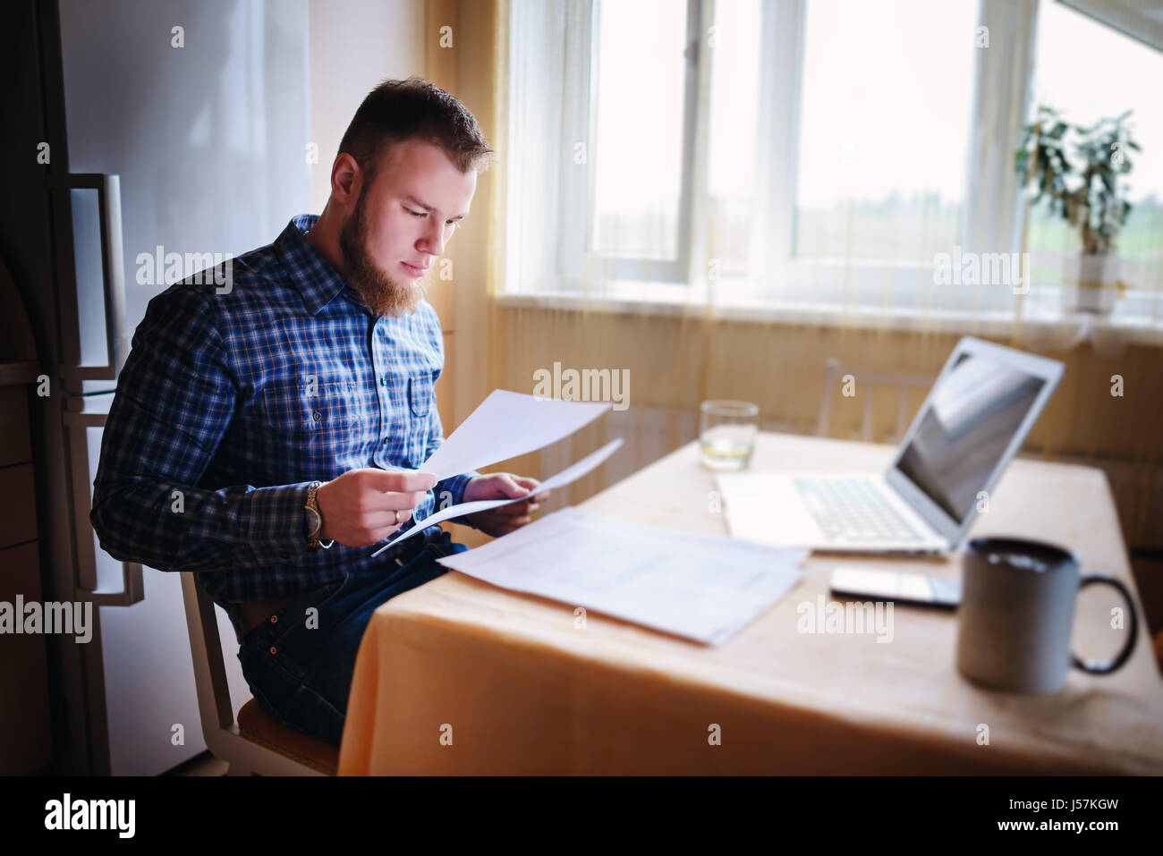 Handsome man doing some paperwork at home Stock Photo - Alamy