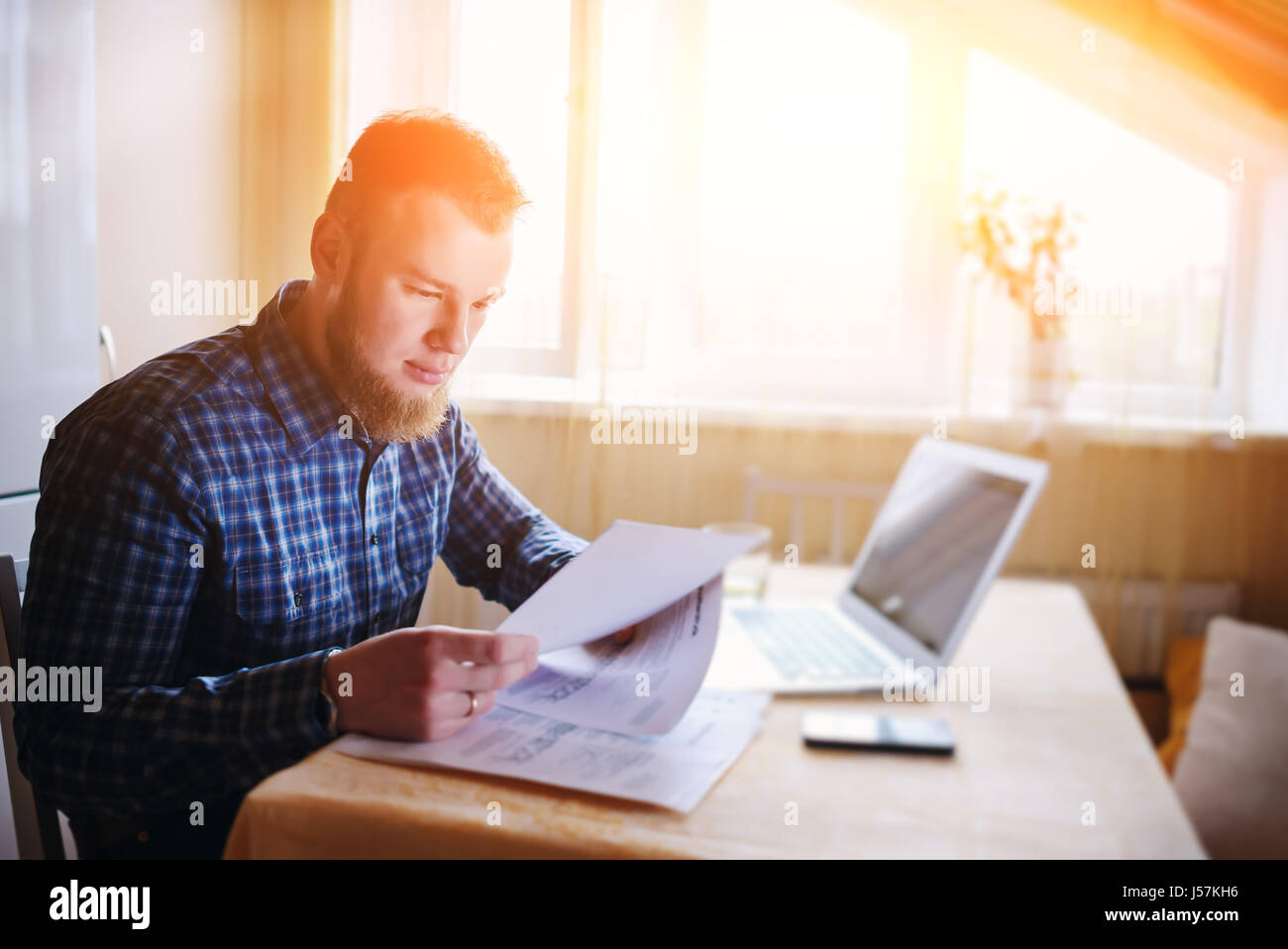 Handsome man doing some paperwork at home Stock Photo - Alamy