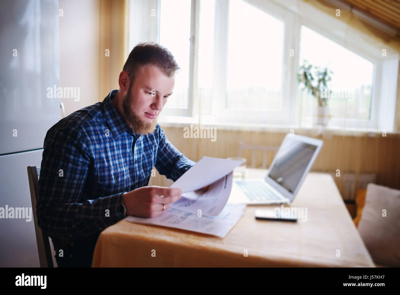 Handsome man doing some paperwork at home Stock Photo - Alamy