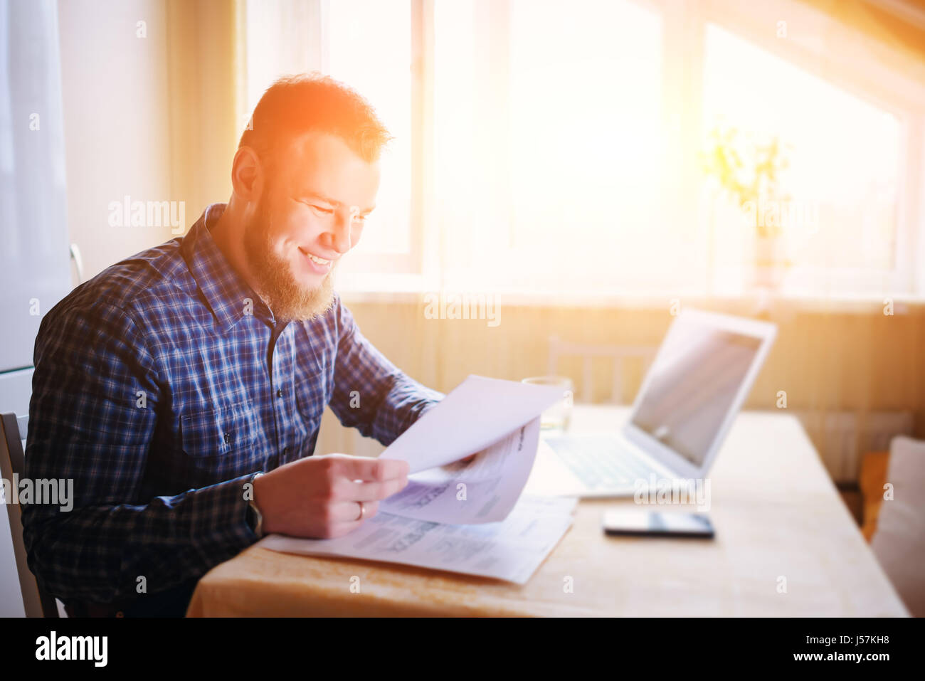 Handsome man doing some paperwork at home Stock Photo - Alamy