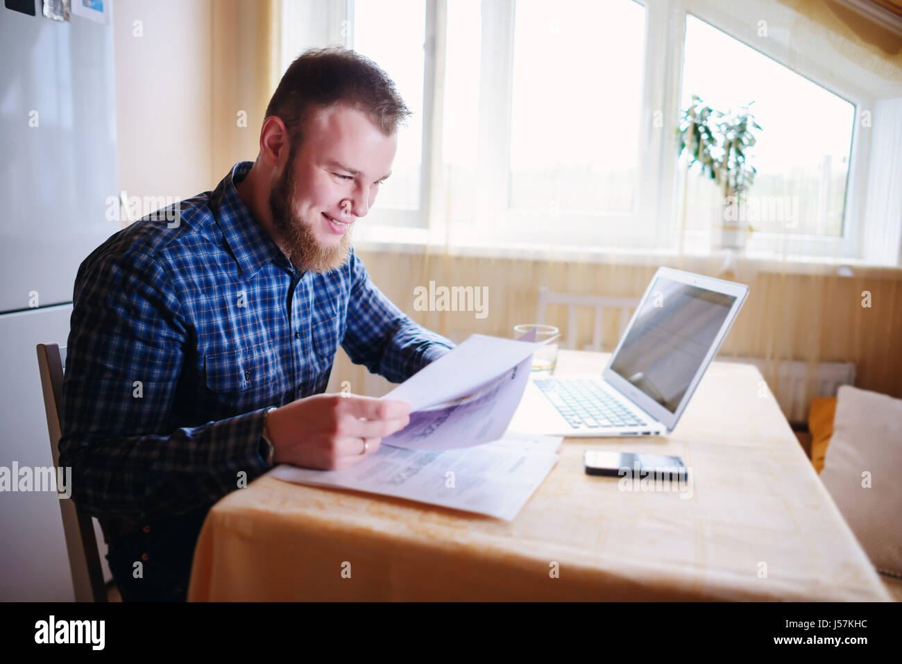 Handsome man doing some paperwork at home Stock Photo - Alamy