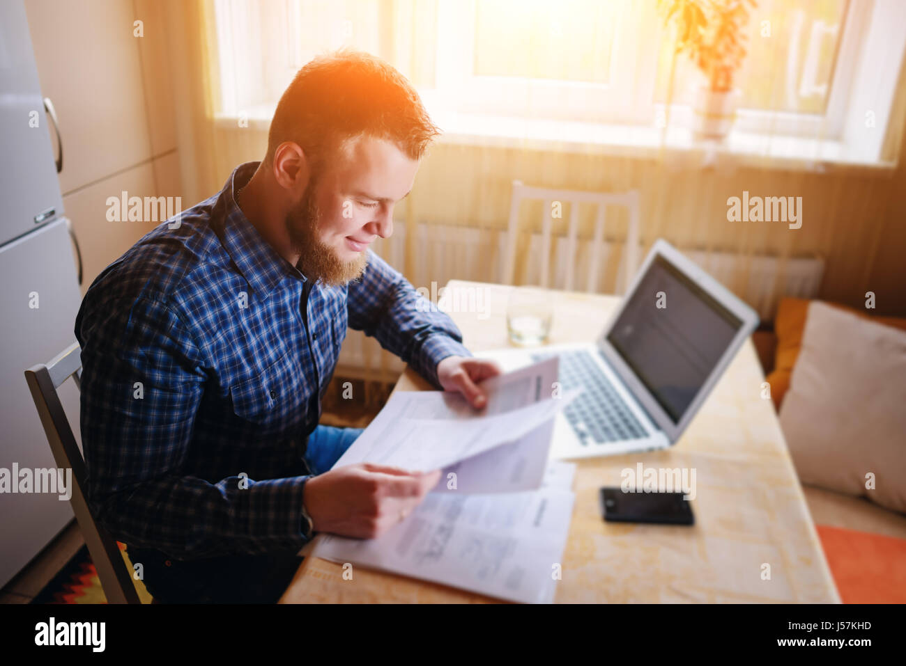 Handsome man doing some paperwork at home Stock Photo - Alamy