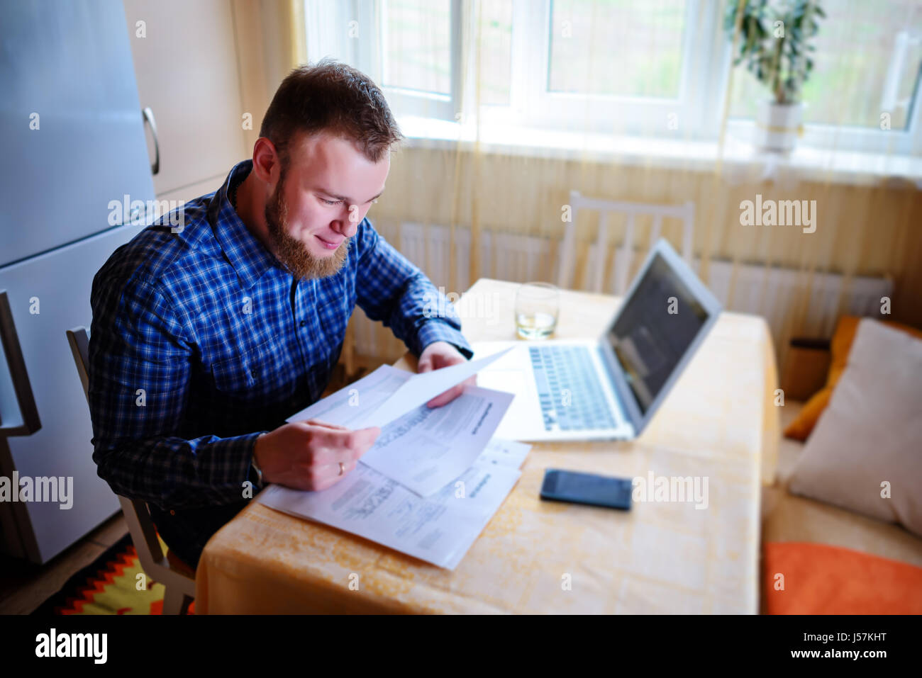 Handsome man doing some paperwork at home Stock Photo - Alamy