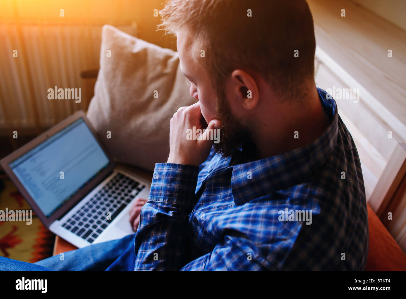 Young man working with computer on the beach. Handsome man working with ...