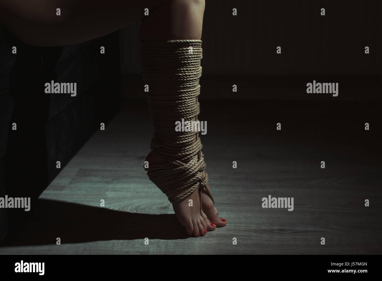 Beautiful legs tied with rope in bondage. Photo toning Stock Photo - Alamy