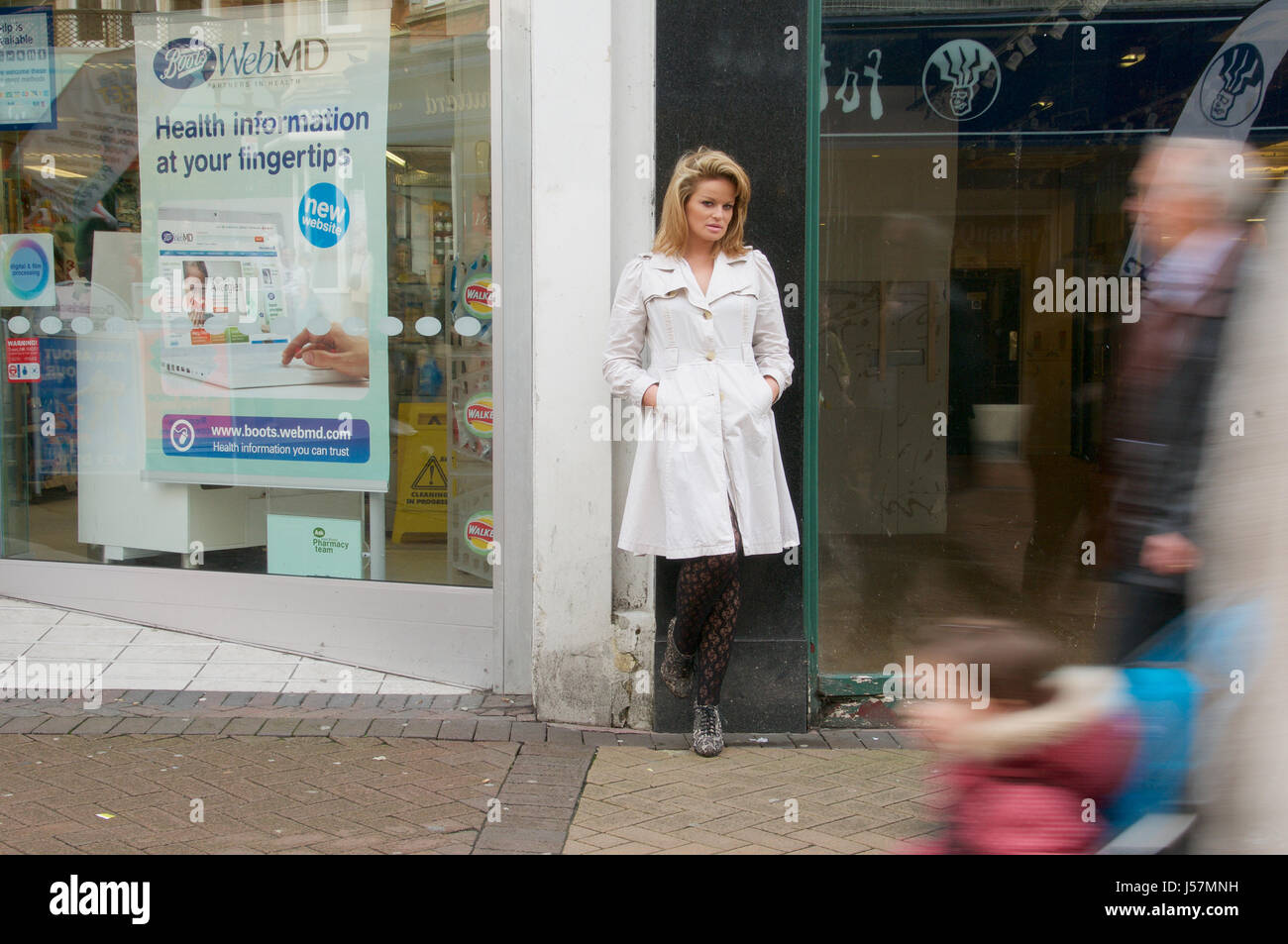 Blonde girl in the street - motion blur of passing people Stock Photo ...