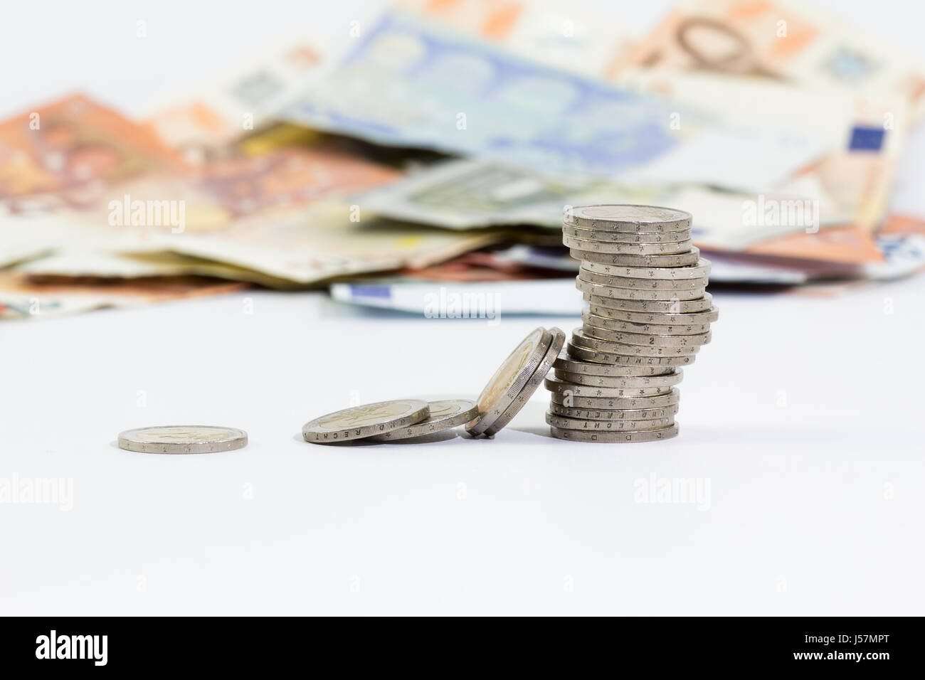 2 euro coins stacked and euro banknotes on a white background Stock ...