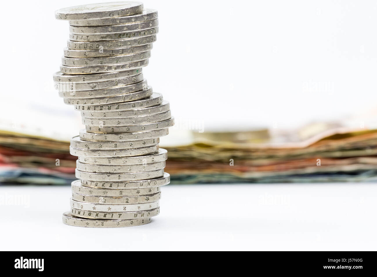 2 euro coins stacked and euro banknotes on a white background Stock ...