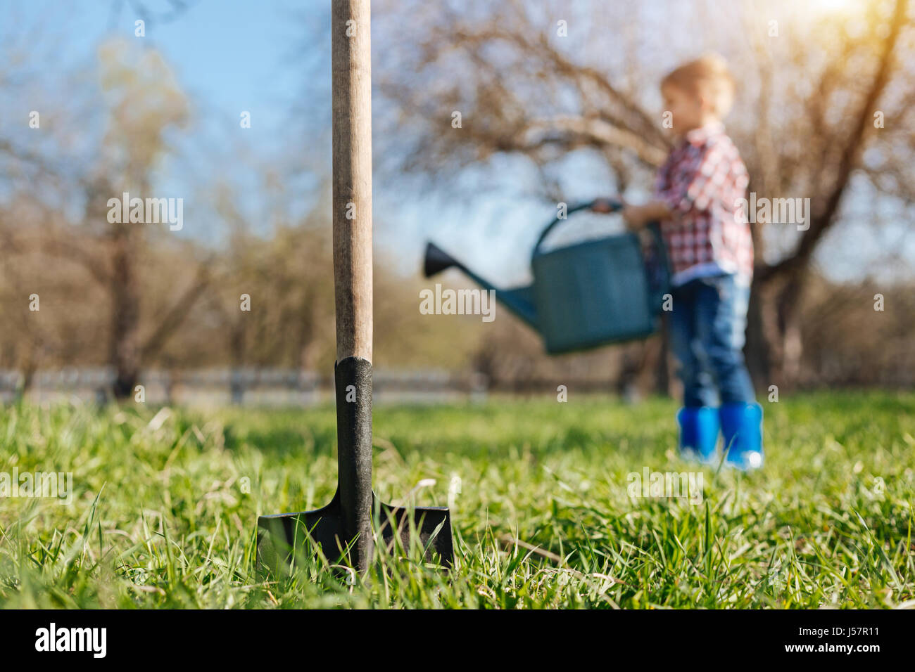 Close up of spade digging soil with child on background Stock Photo - Alamy