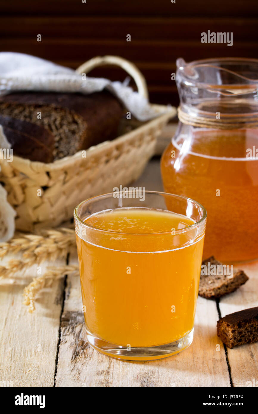 Traditional Russian cold rye drink Kvas in a glass and a jug on a ...