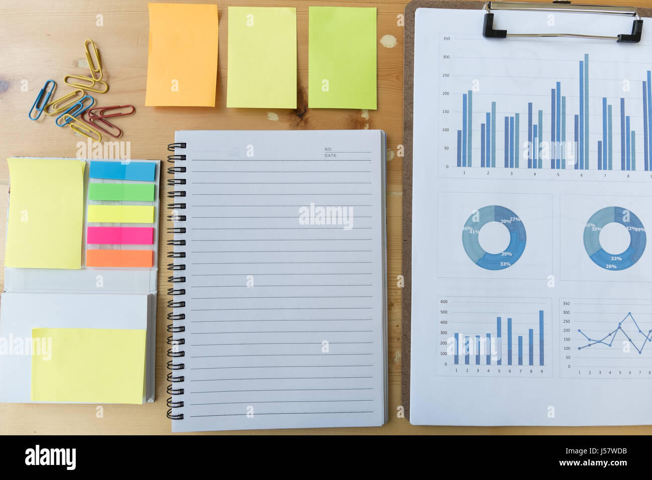 marketing graph and chart report with blank notebook, sticky note ...