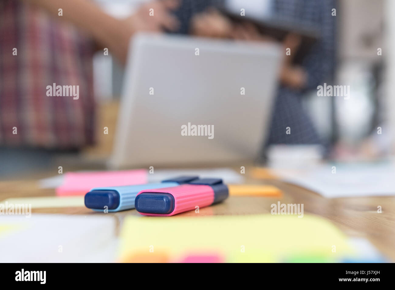 highlighter on desk with background of startup young successful team on ...