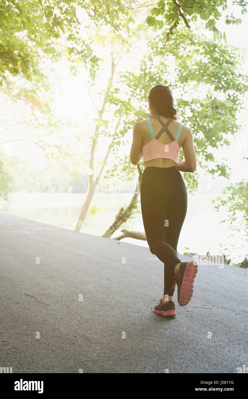 Female sport fitness athlete runner jogging outdoors in spring or ...