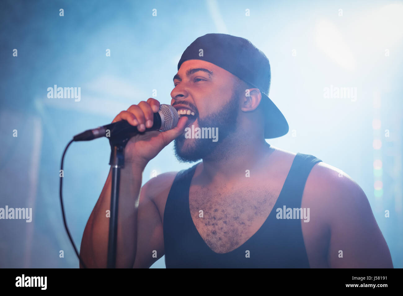 Close up of musician holding microphone while singing in nightclub ...