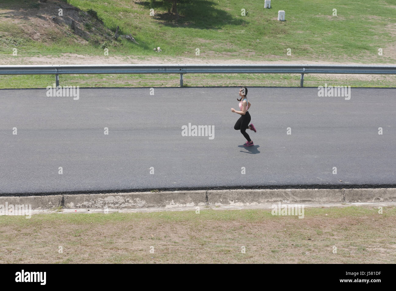 Female sport fitness athlete runner jogging outdoors in spring or ...
