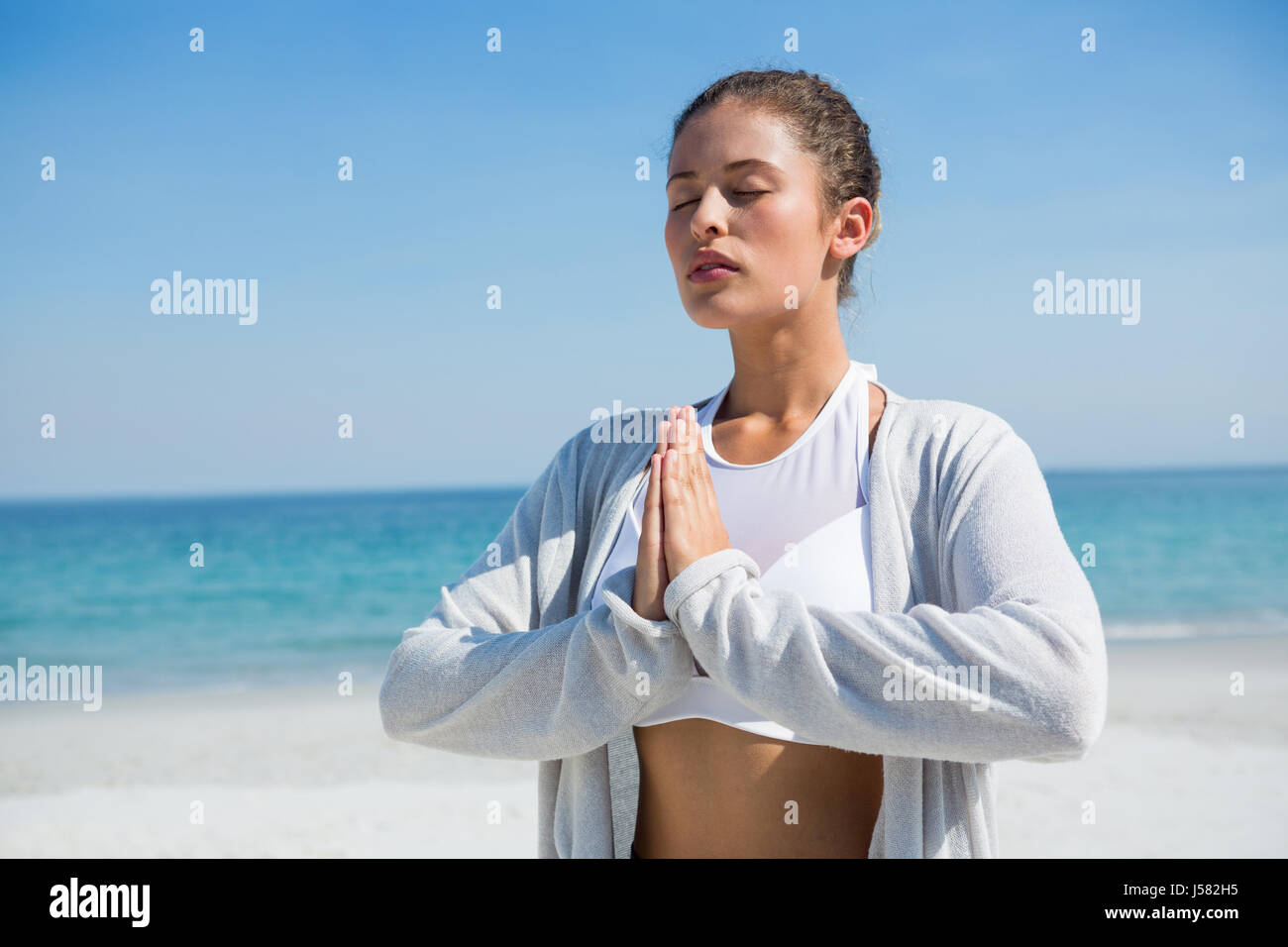 Close up of woman in prayer position standing at beach Stock Photo - Alamy