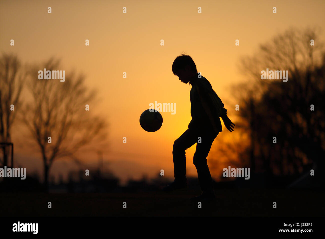 Boy Lifting Ball Stock Photo - Alamy