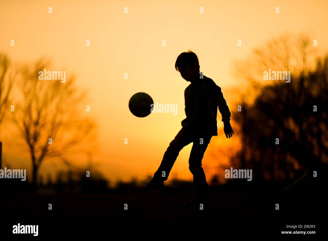 Boy Lifting Ball Stock Photo - Alamy