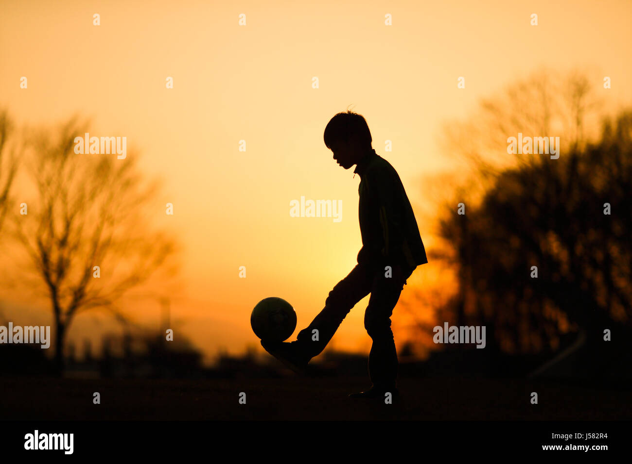 Boy Lifting Ball Stock Photo - Alamy