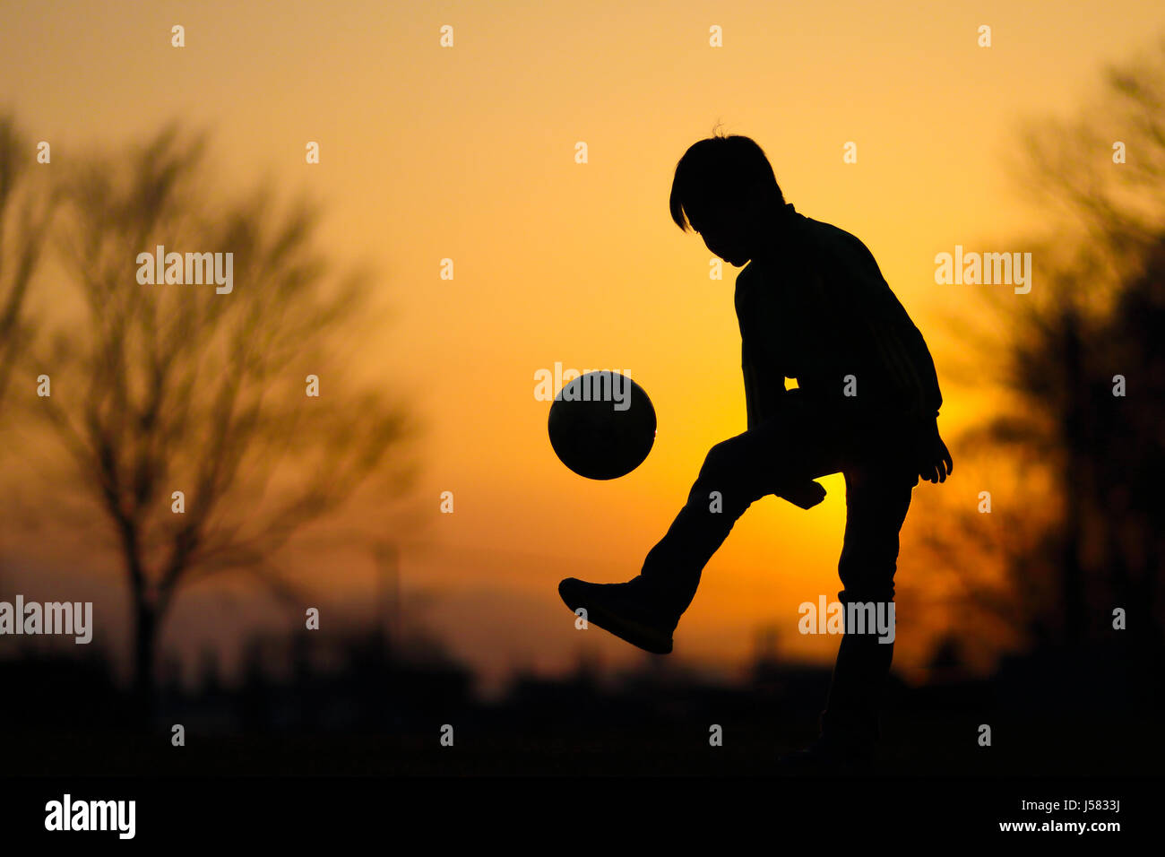 Boy Lifting Ball Stock Photo - Alamy