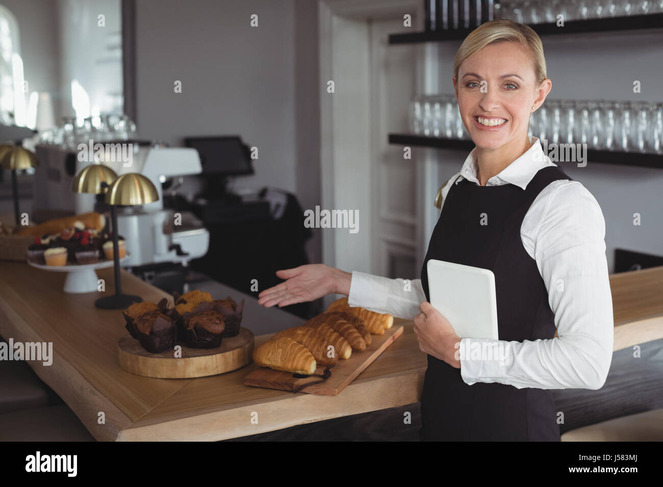 Portrait of smiling waitress standing at counter in restaurant Stock ...