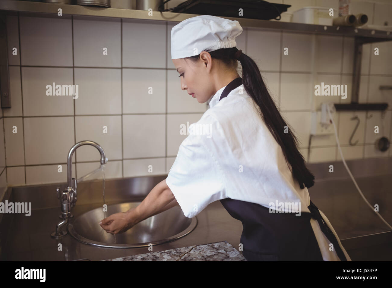 Female chef washing hands in the commercial kitchen at restaurant Stock ...