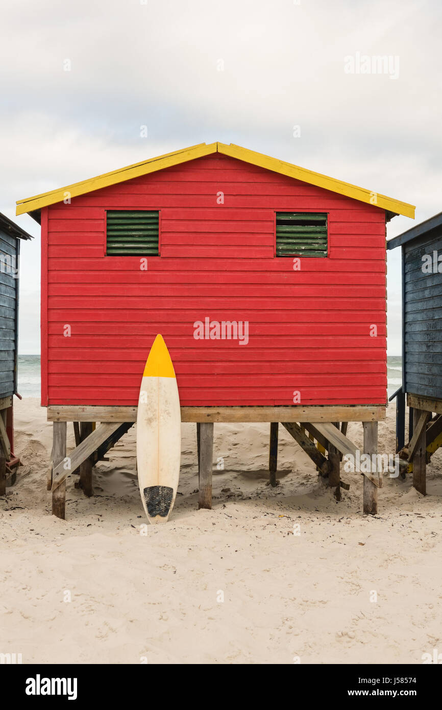 Surfboard by red wooden hut at beach Stock Photo - Alamy