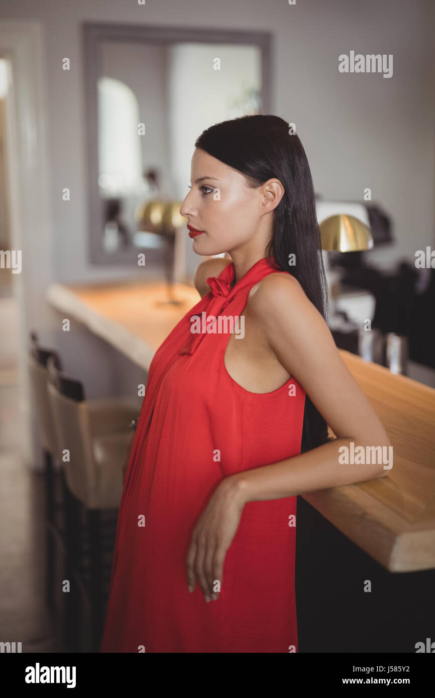 Thoughtful woman leaning against a counter in restaurant Stock Photo ...