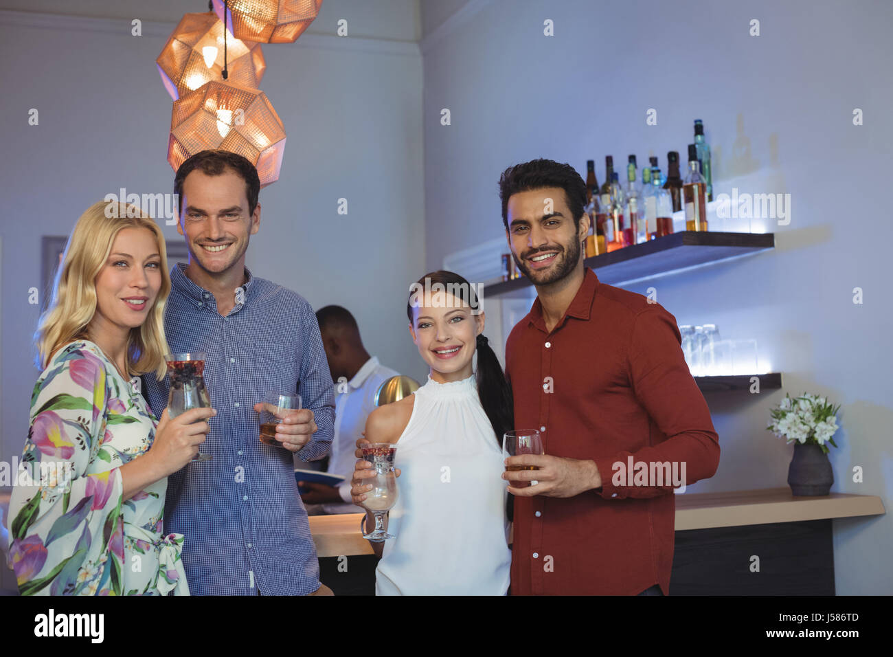 Portrait of smiling two couples having cocktails together in bar ...