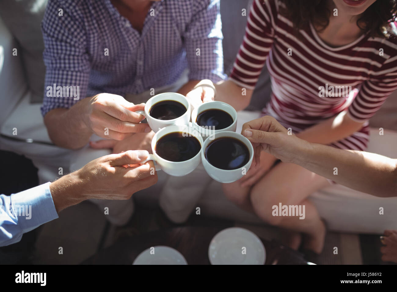 Friend toasting coffee cups together at restaurant Stock Photo - Alamy