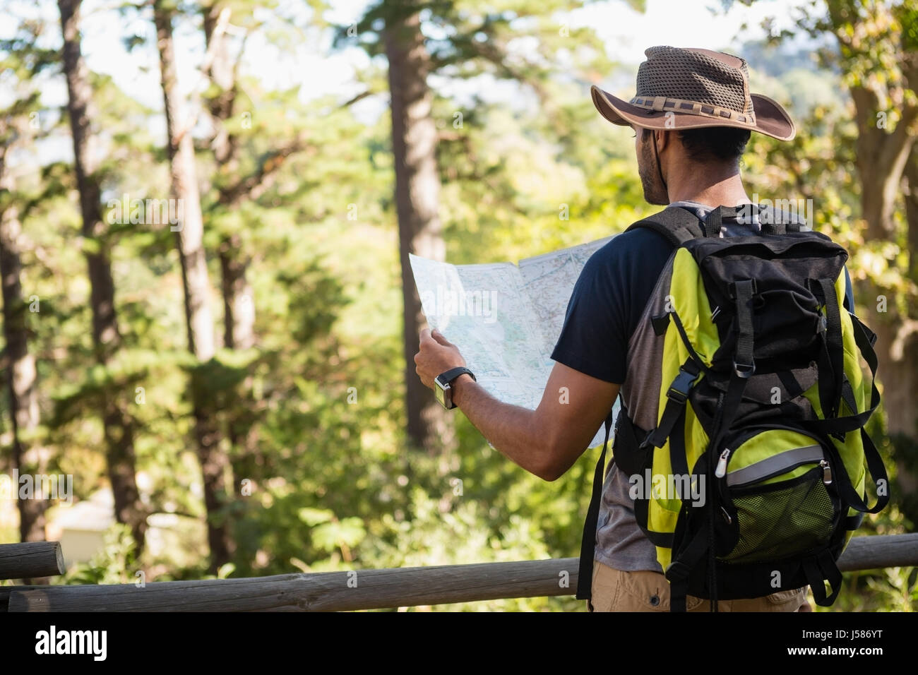 Man reading the map near the wooden fence in forest Stock Photo - Alamy