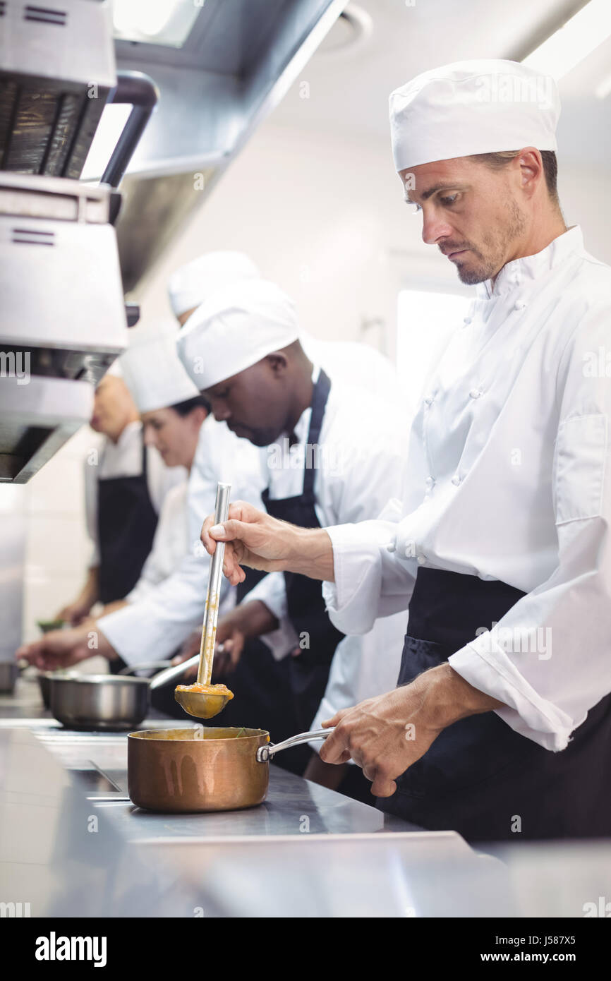 Team of chef preparing food in the commercial kitchen at restaurant ...