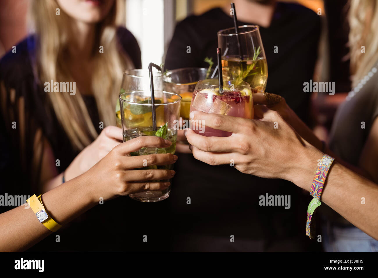 Close up of friends toasting drinks in nightclub Stock Photo - Alamy